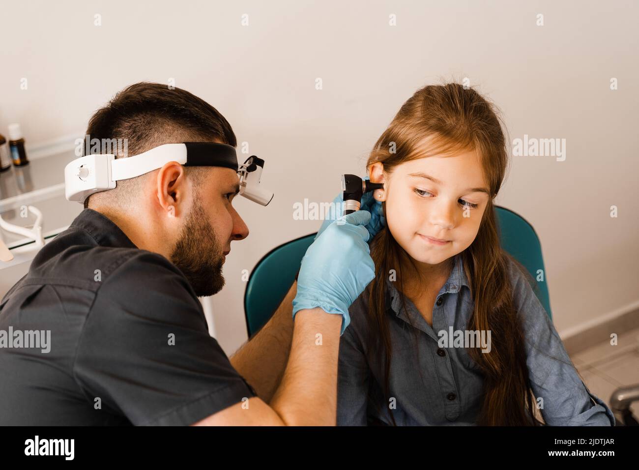 ENT doctor with otoscope. Otoscopy. Pediatrician otolaryngologist looks ...