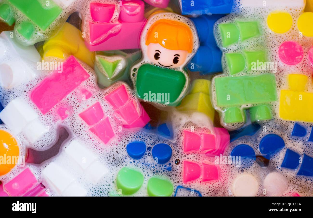 Washing of children toys, plastic building blocks with figurines. A ...