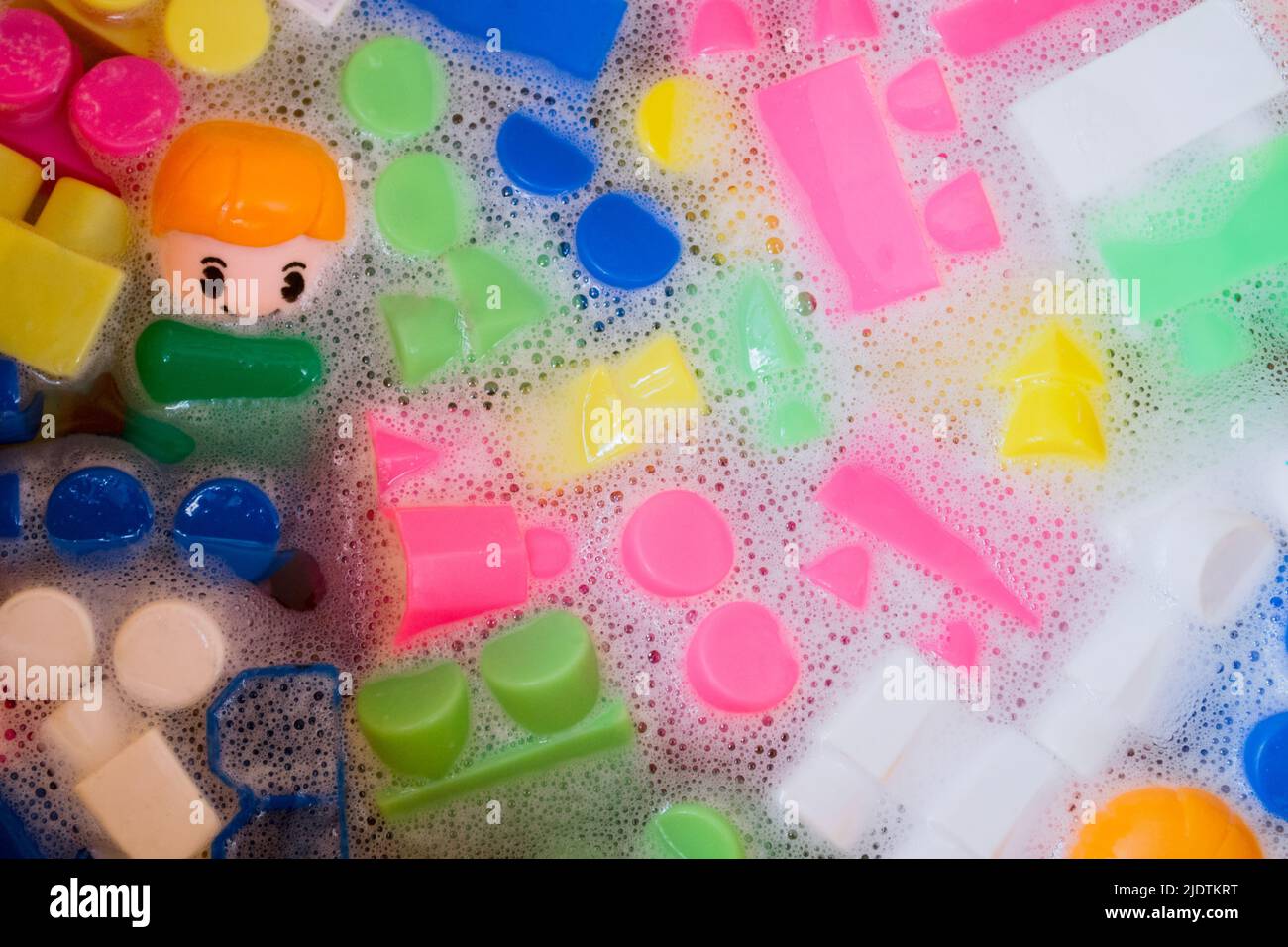 Washing of children toys, plastic building blocks with figurines. A ...