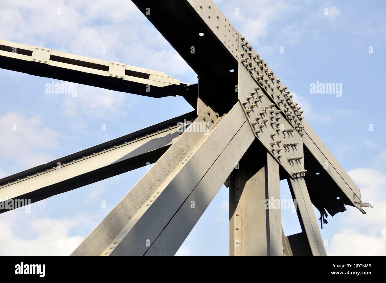 A war-torn railroad bridge truss against the sky. Russian-Ukrainian war ...