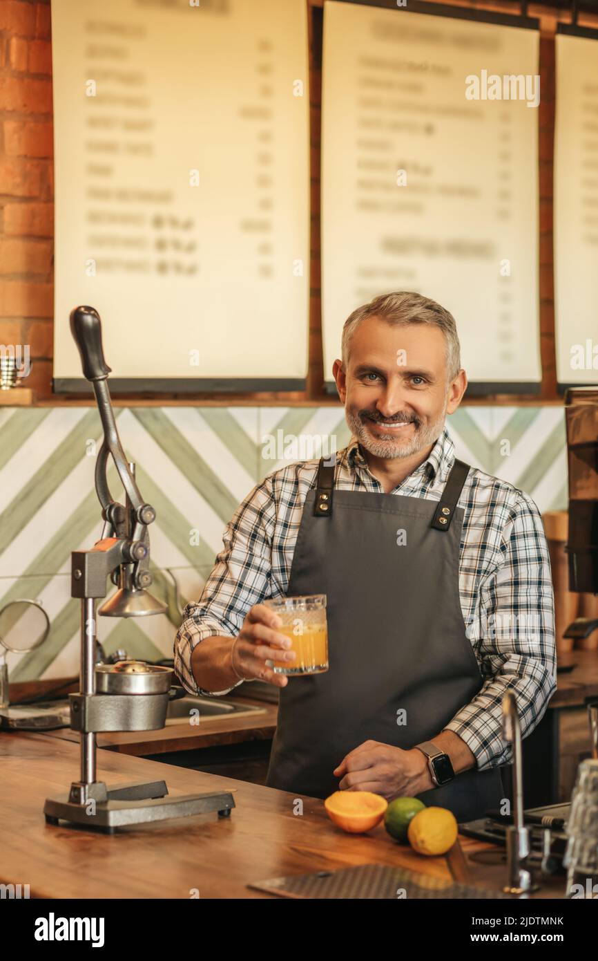 Man holding glass of juice smiling at camera Stock Photo - Alamy