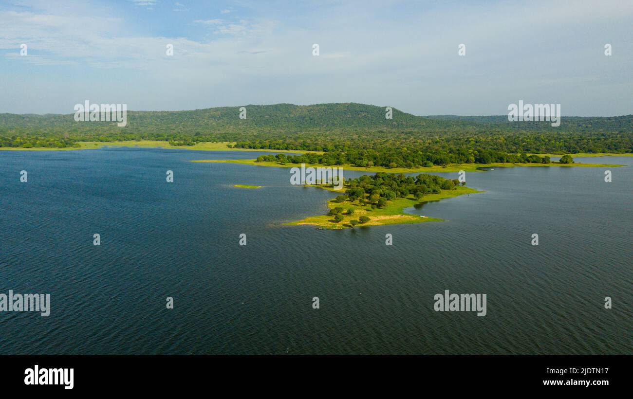 A lake with islands covered with rainforest and vegetation. Kantale ...