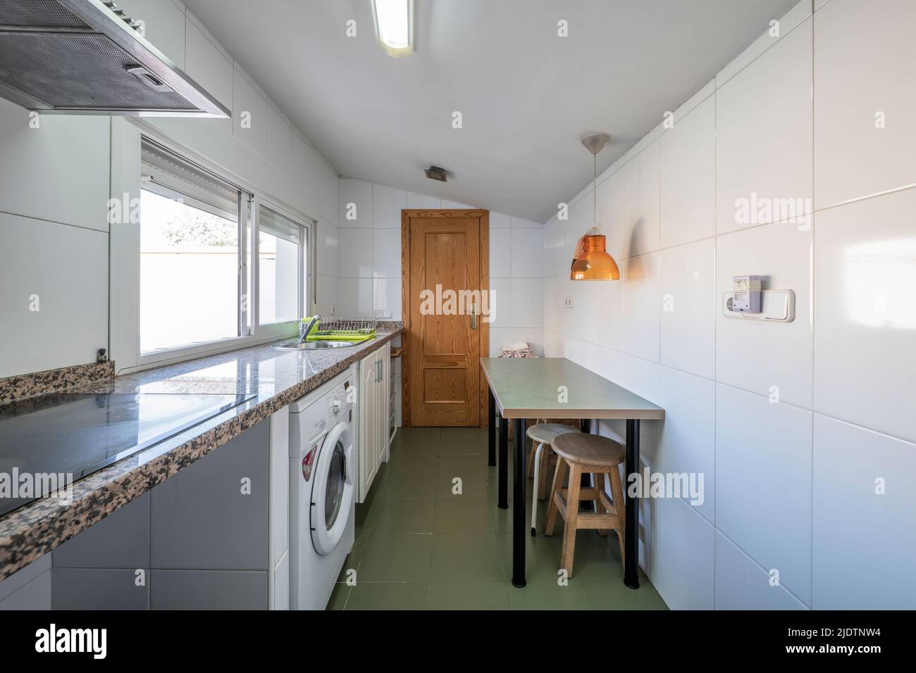 Kitchen of a house with sloping ceilings with green wooden table, pine ...