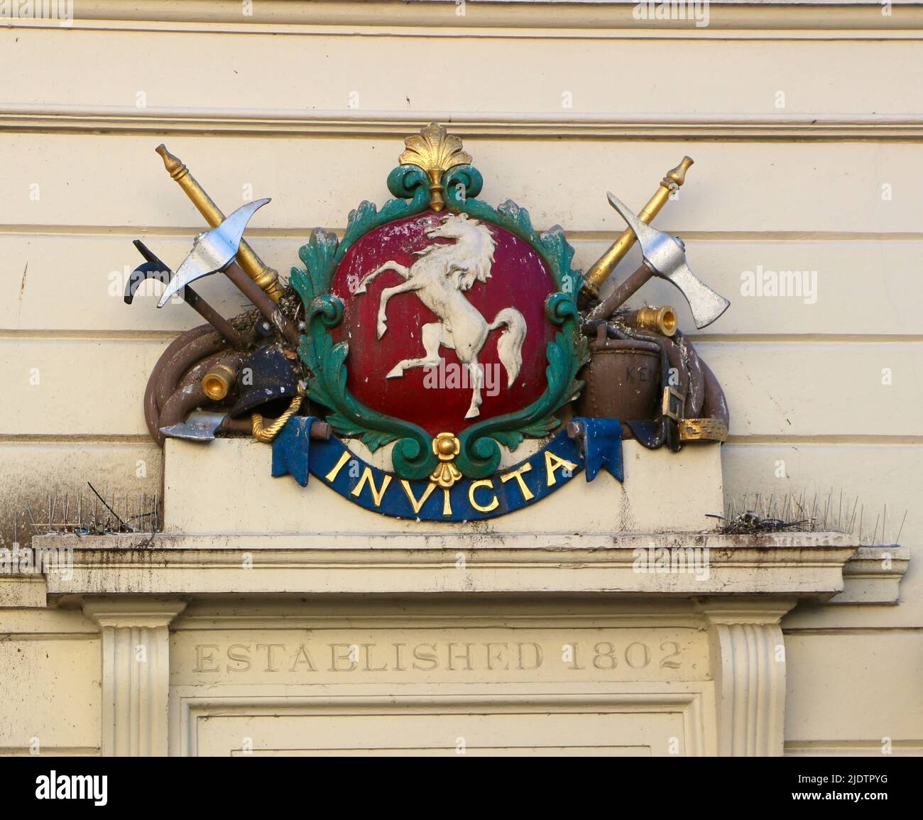 Coat of arms of the Kent Fire brigade over the entrance to a building ...