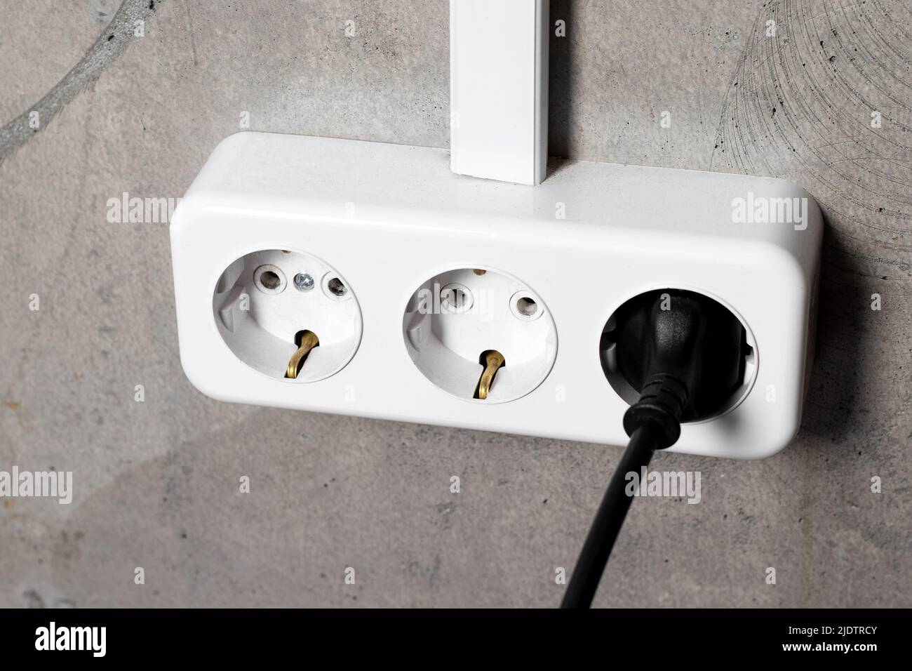 Group of white european electrical outlets with plug on gray concrete ...