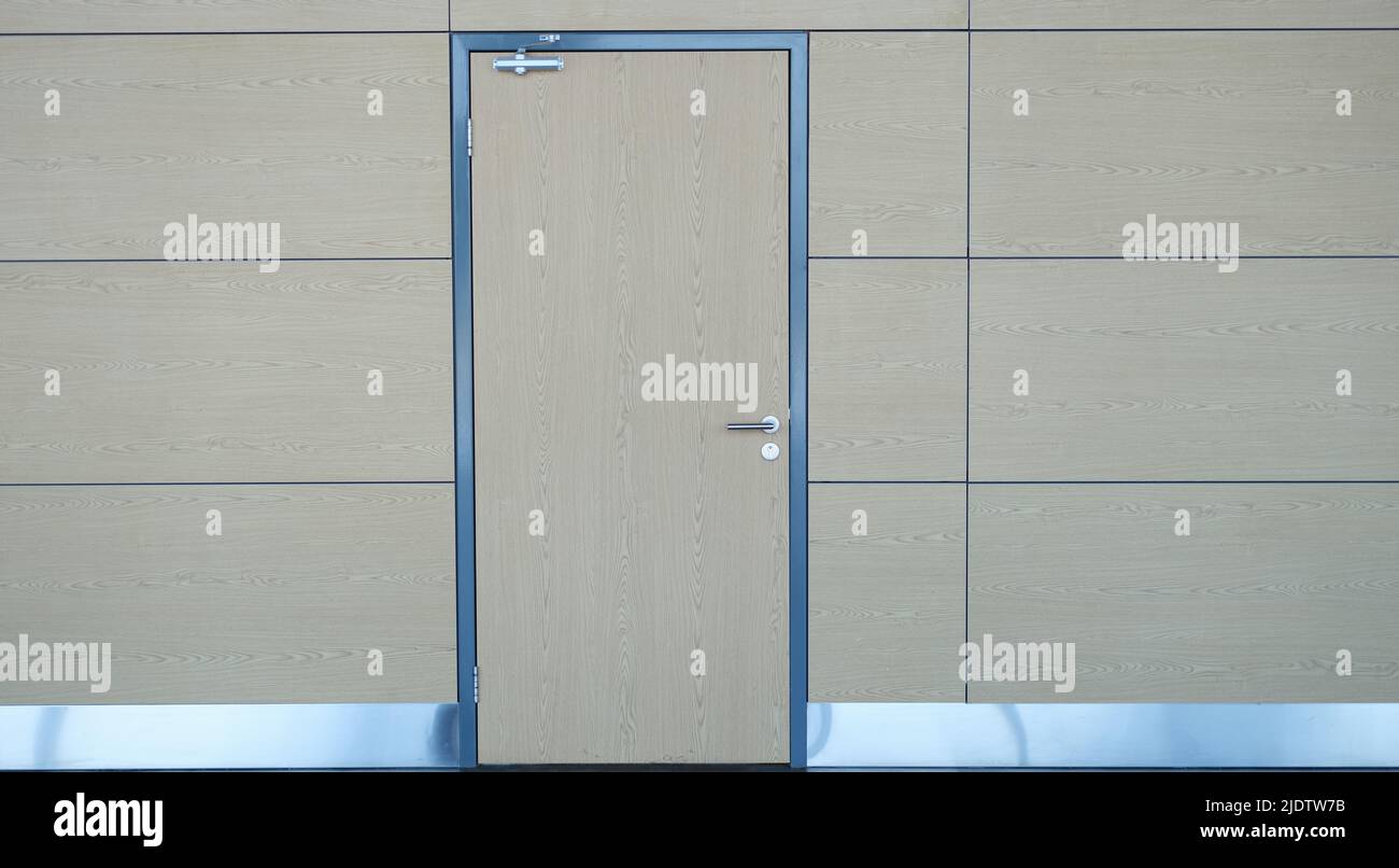 Wooden door to match wall in building background Stock Photo - Alamy