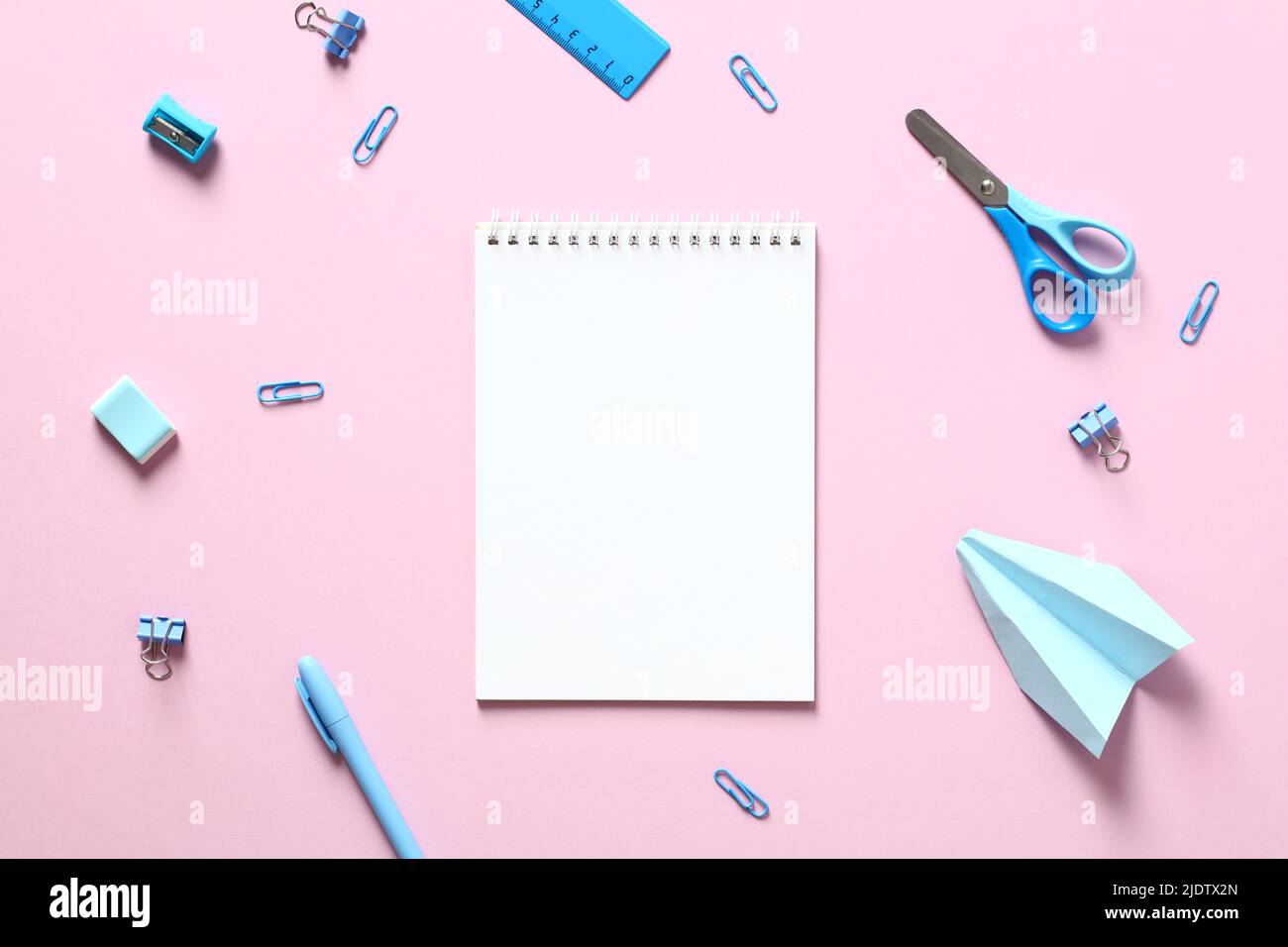 Flat lay blank paper notepad mockup with blue school supplies on pink ...