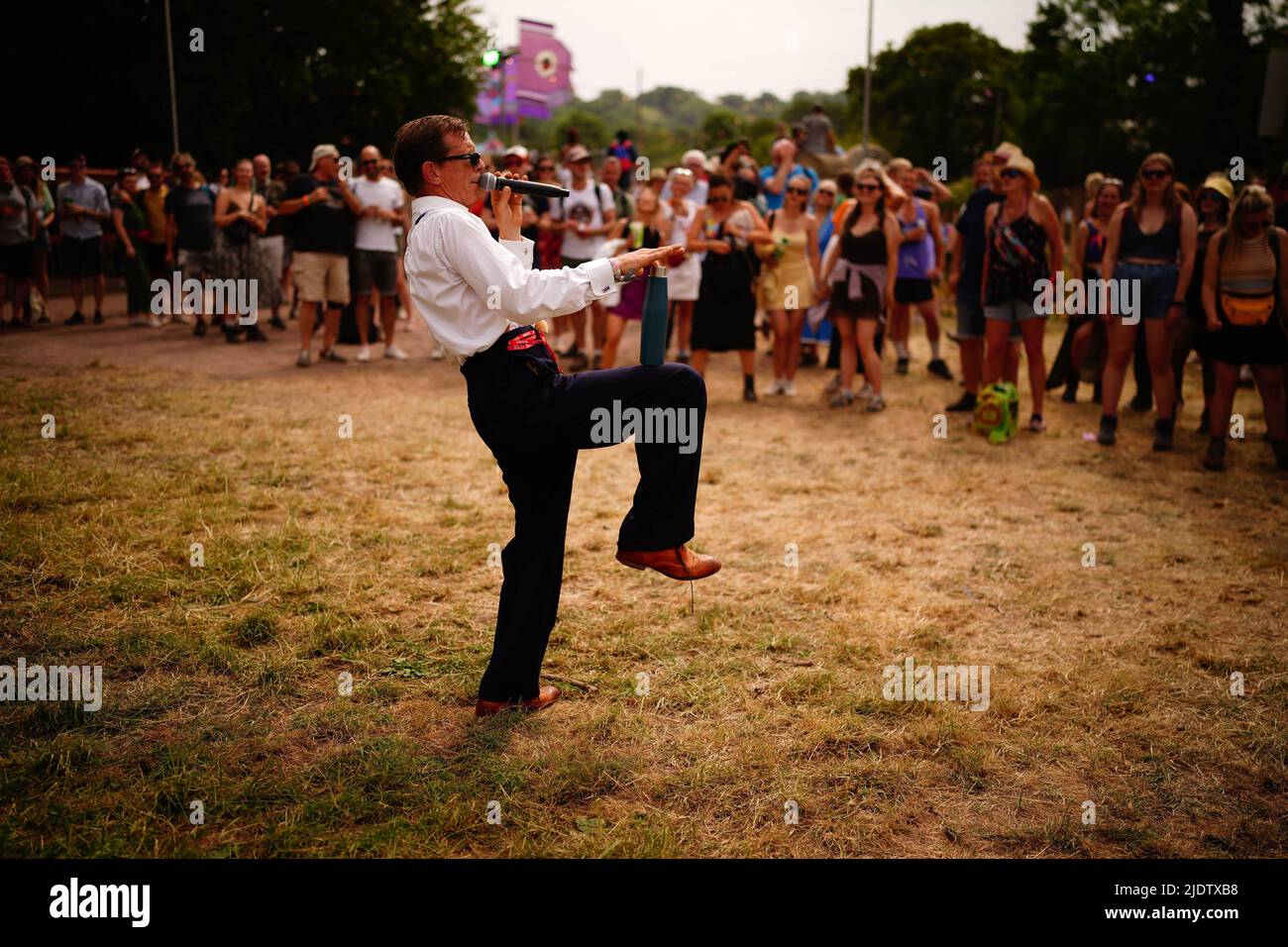 Festival-goers watch a 'crooner' style singer perform during the ...