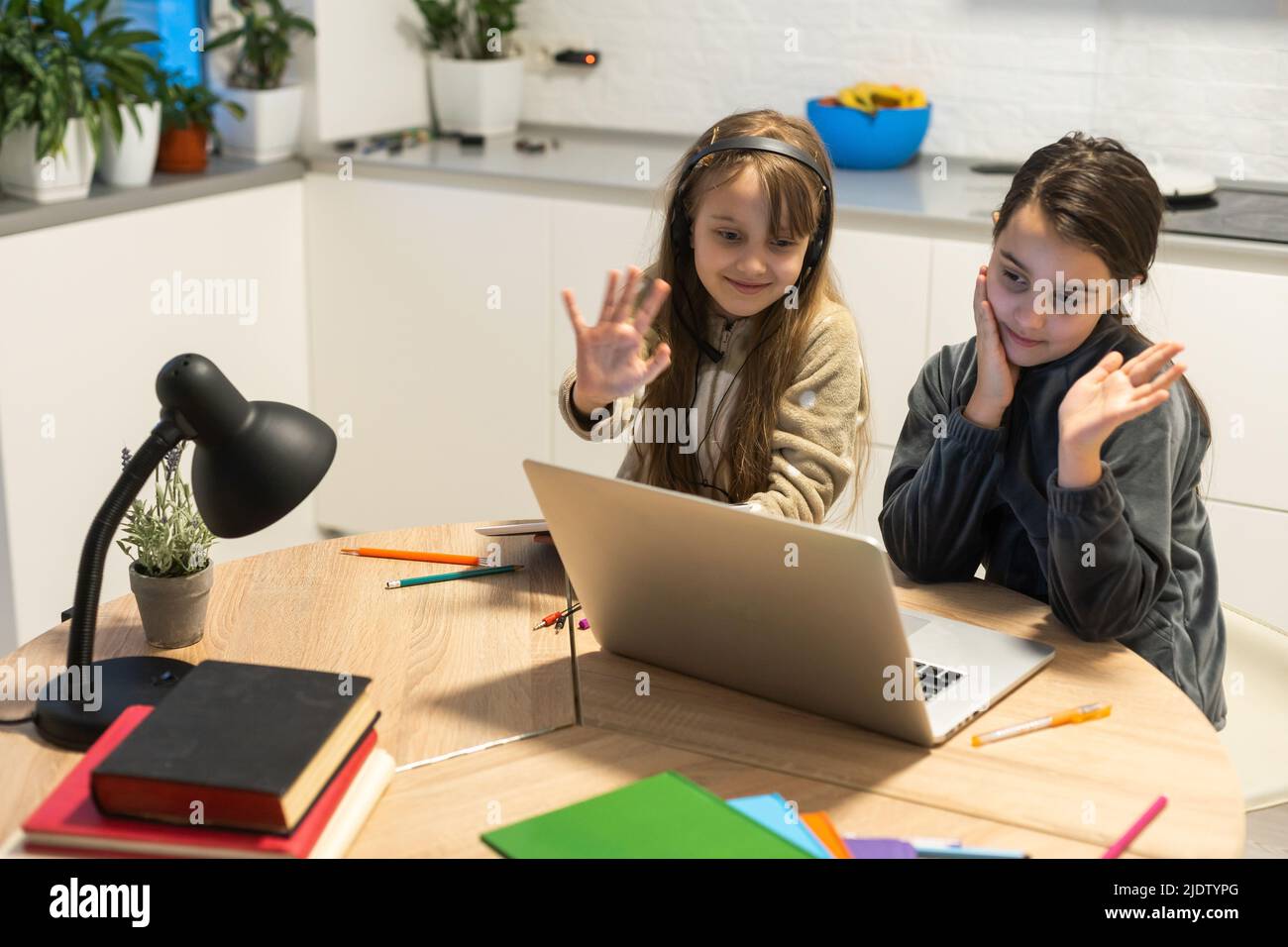 Two child girl students study online with teacher by video call ...