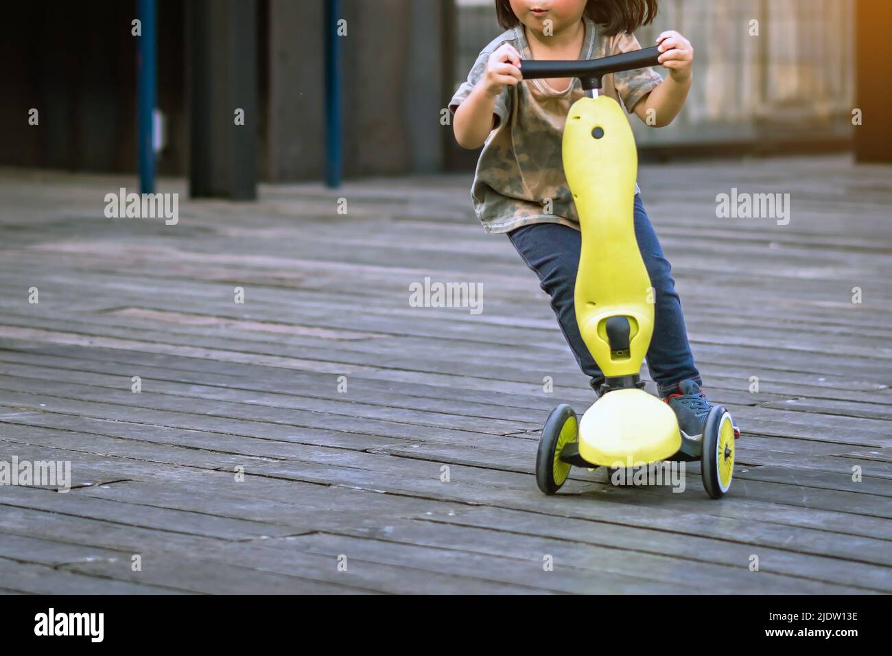 Asian kid enjoy playing and riding scooter without using any safety ...