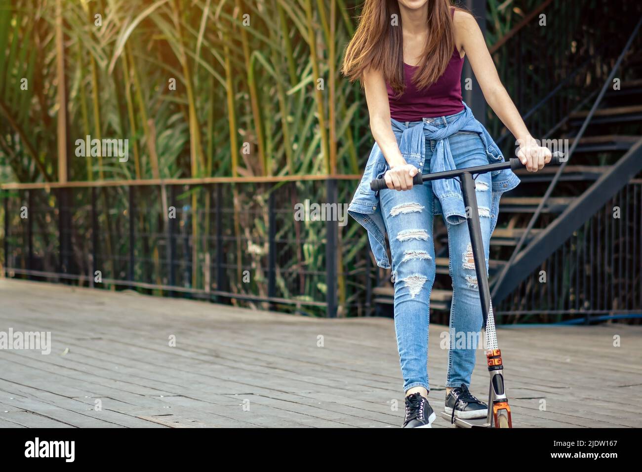 Asian woman enjoy playing and riding modern extreme stunt kick scooter ...