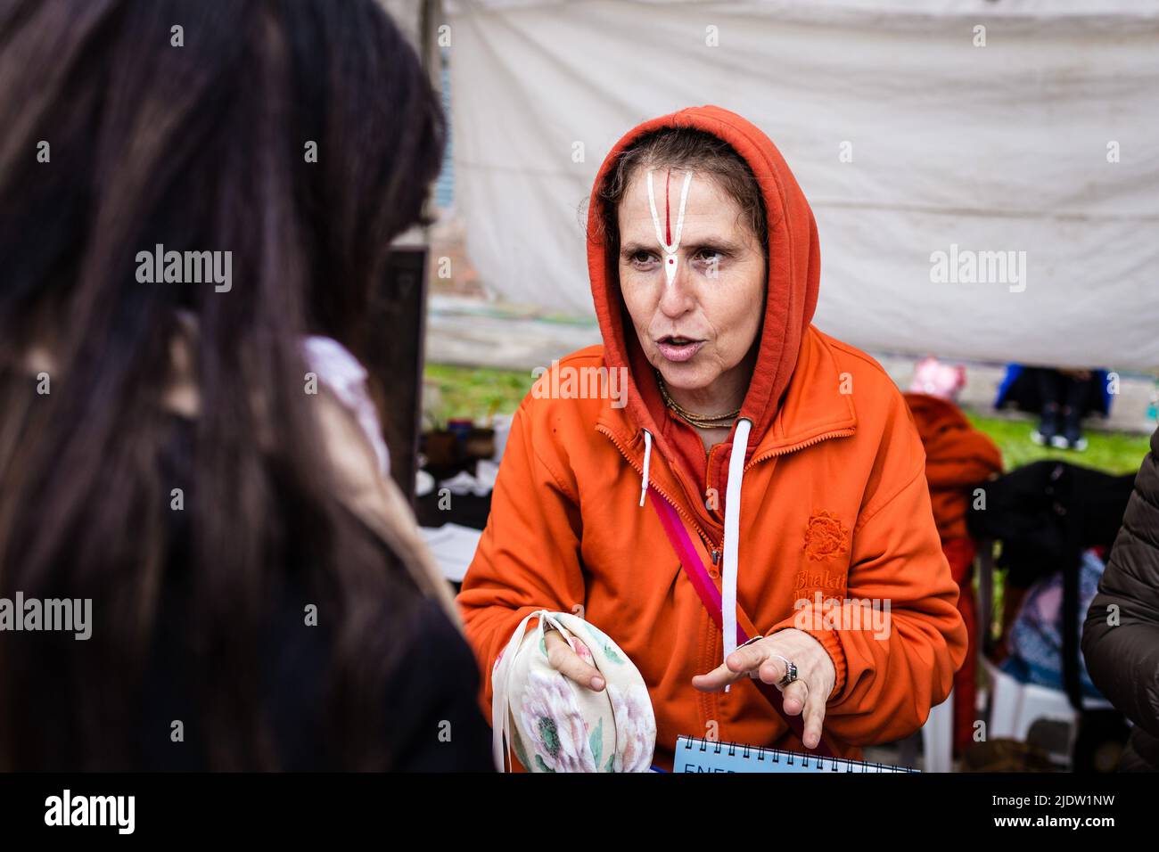 A woman from the Bhakti Marga community seen at her outdoor stall. In ...