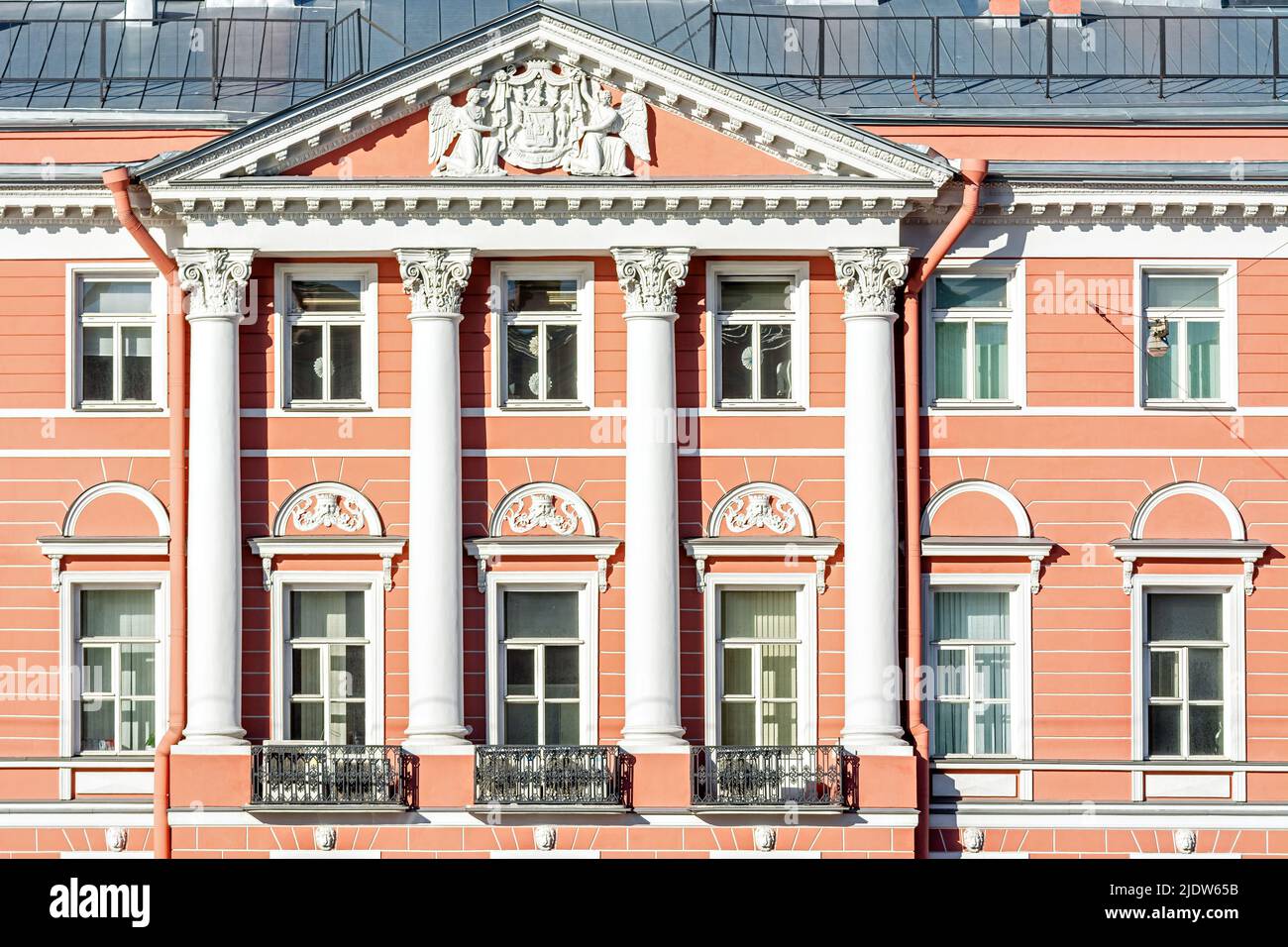 Facade of the building with pink walls with bas-relief, windows ...