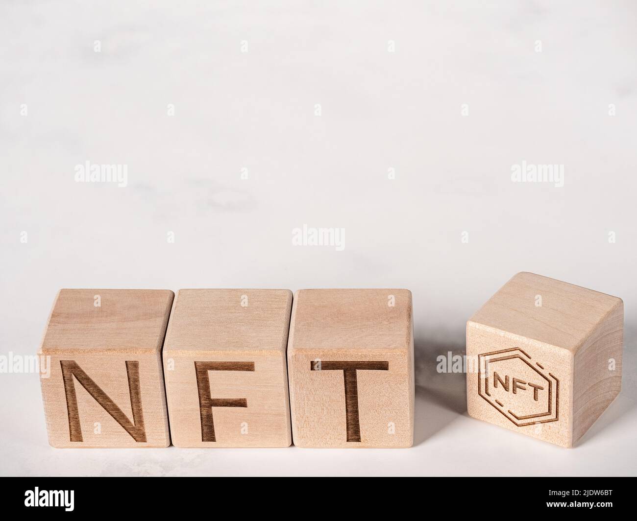 NFT text on wooden blocks as innovation in the digital goods trade ...