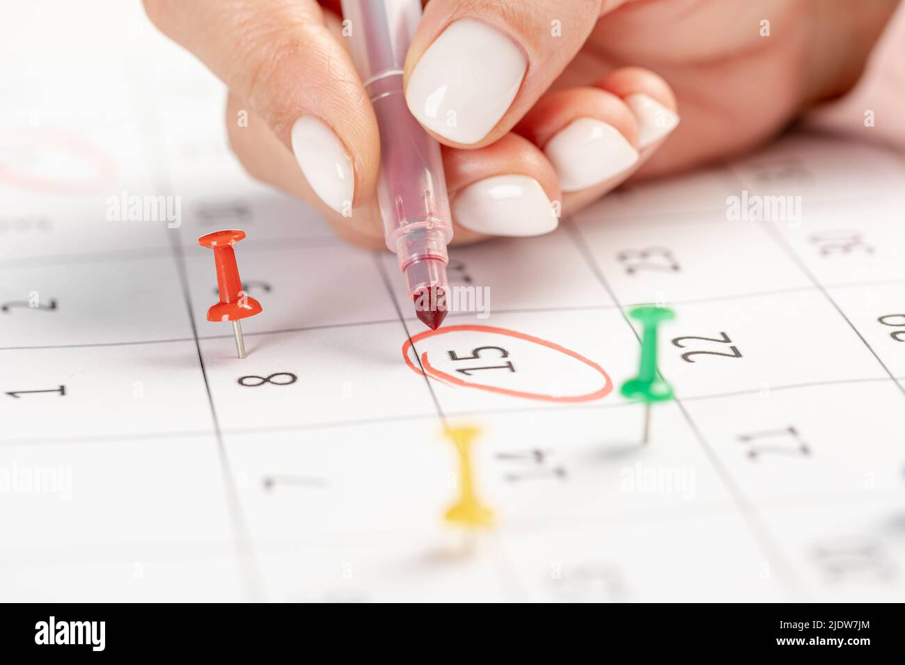 female hand marks with a red marker in the calendar notes an important ...