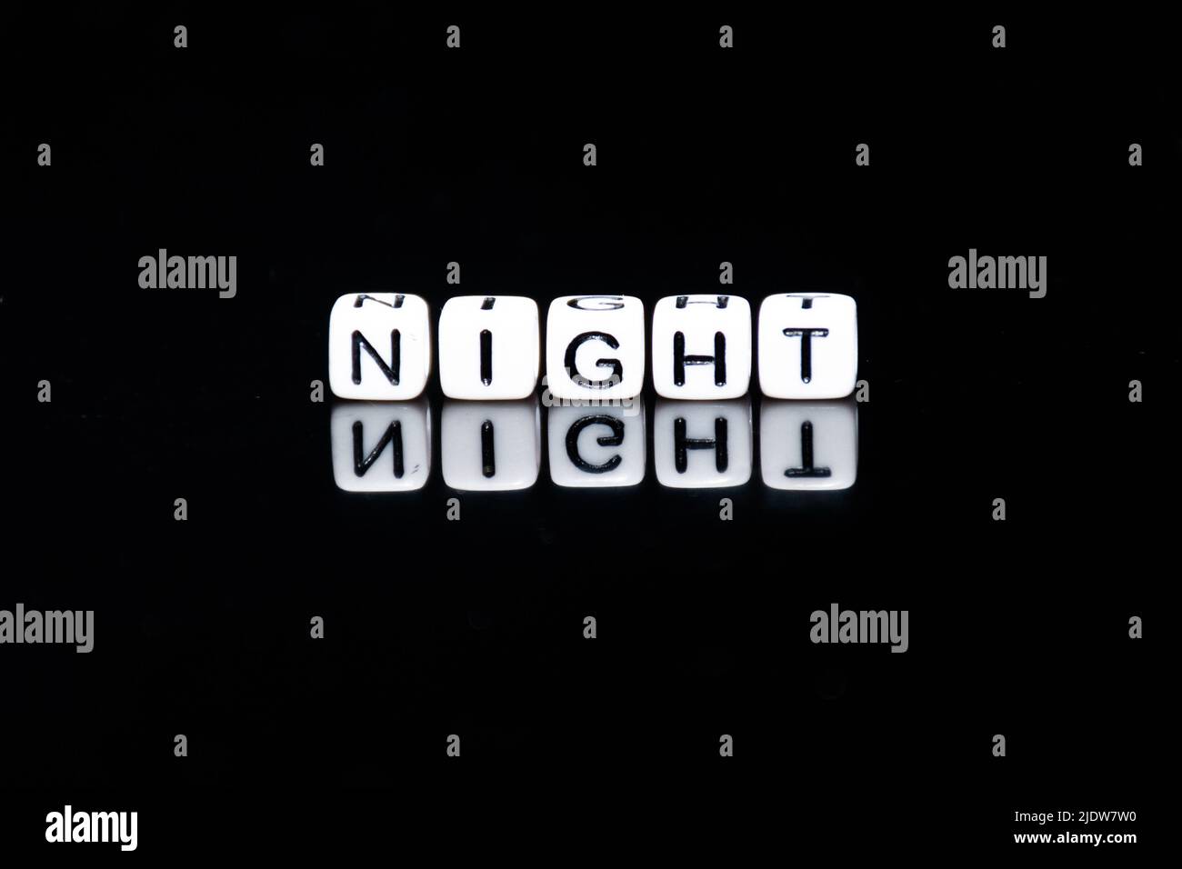 The word of "NIGHT" making from little acrylic cubes in black ...