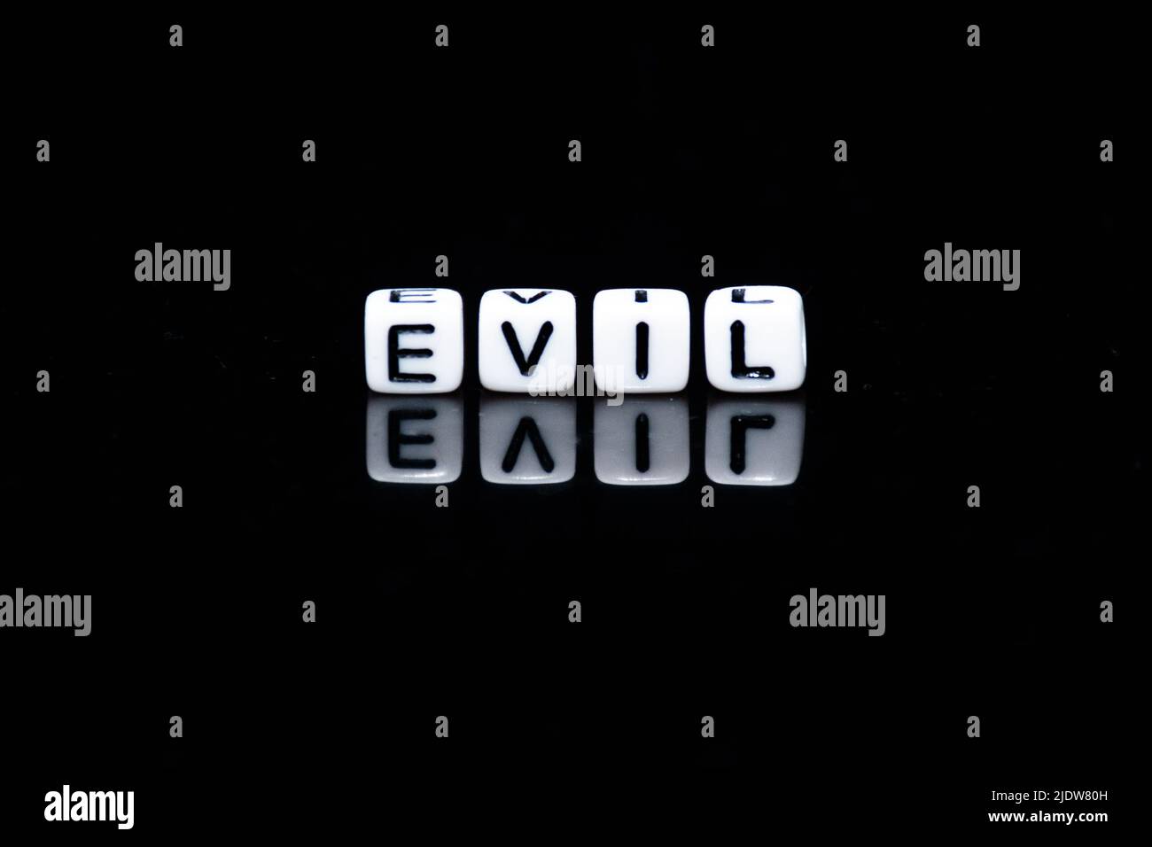 The word of "EVIL" making from little acrylic cubes in black background ...