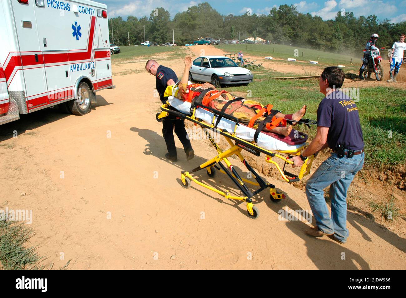 Bike rider with broken leg is taken off on stretcher by medical people ...