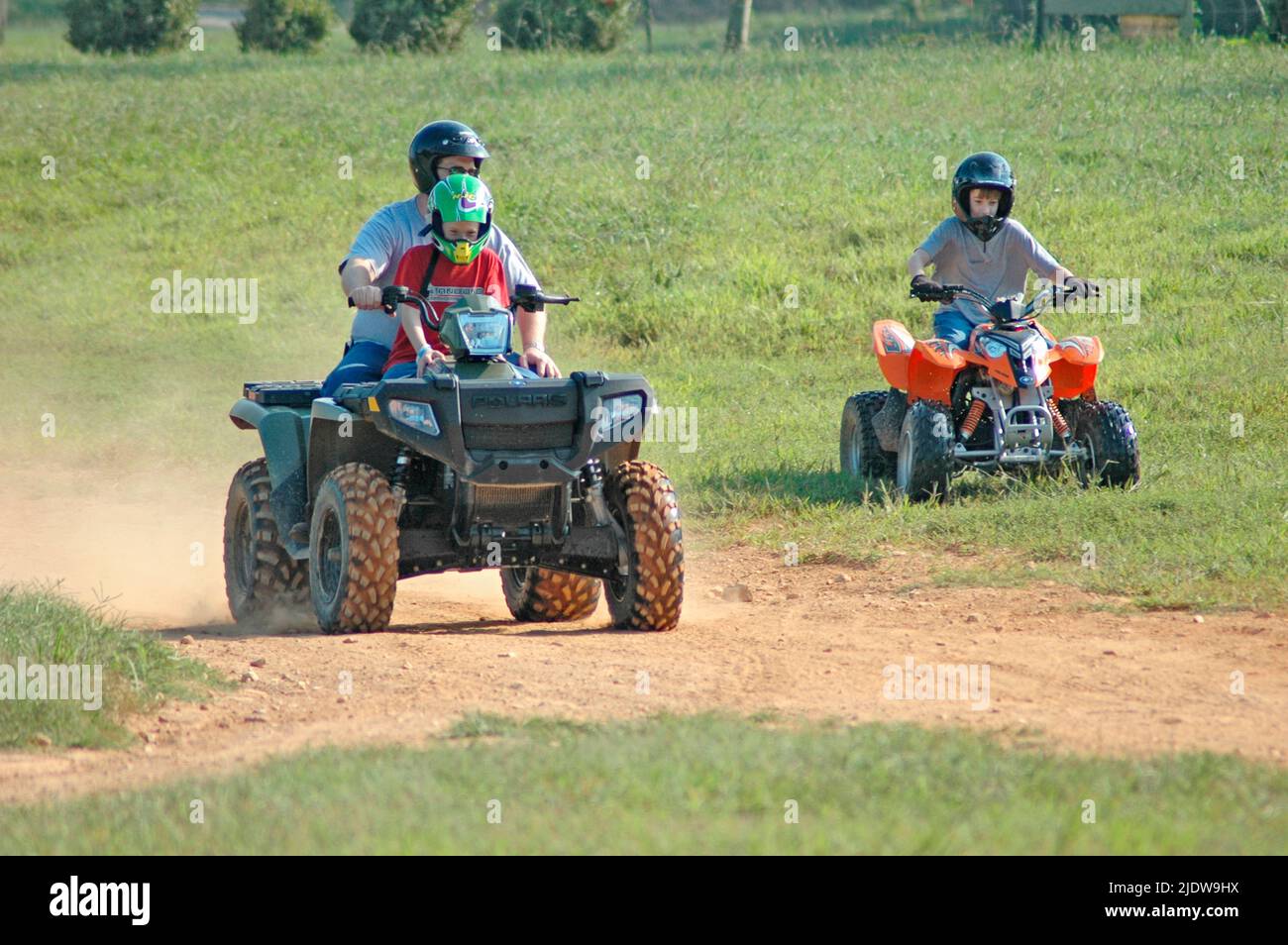 Father and Son on 4 wheeler on dirt road during learning session for ...