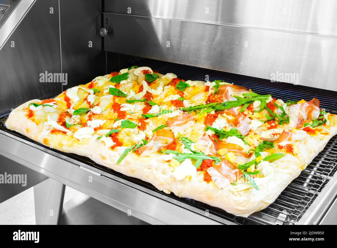 pizza on a square baking sheet before frying Stock Photo - Alamy