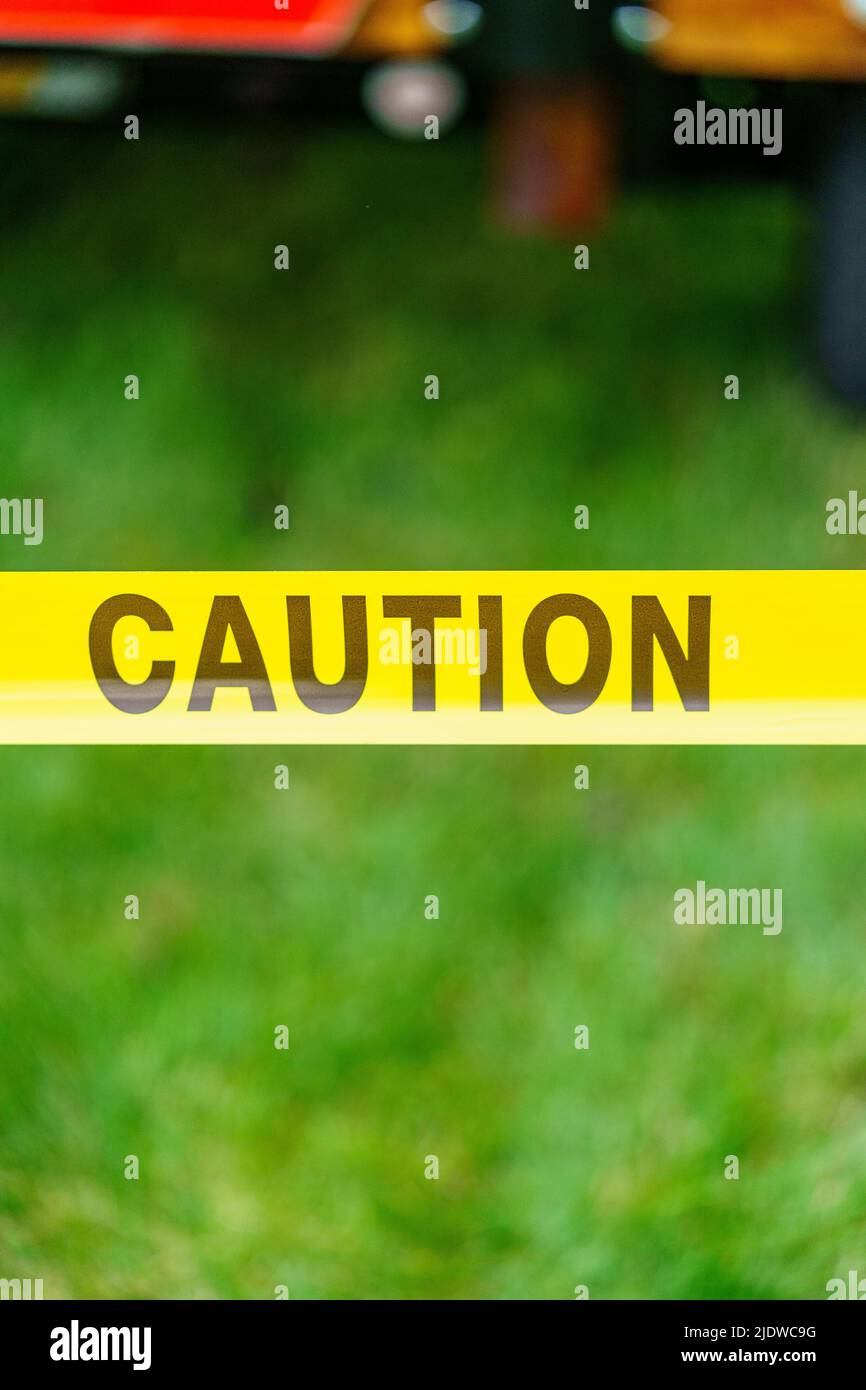 A yellow temporary barrier line with the word “caution” on the tape ...