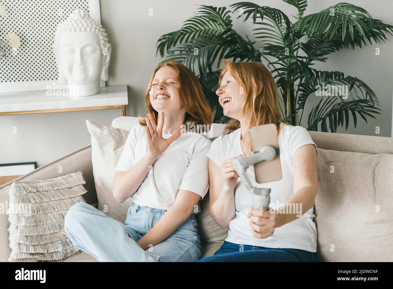 A teenage girl and mother wave a greeting and laugh merrily Stock Photo ...