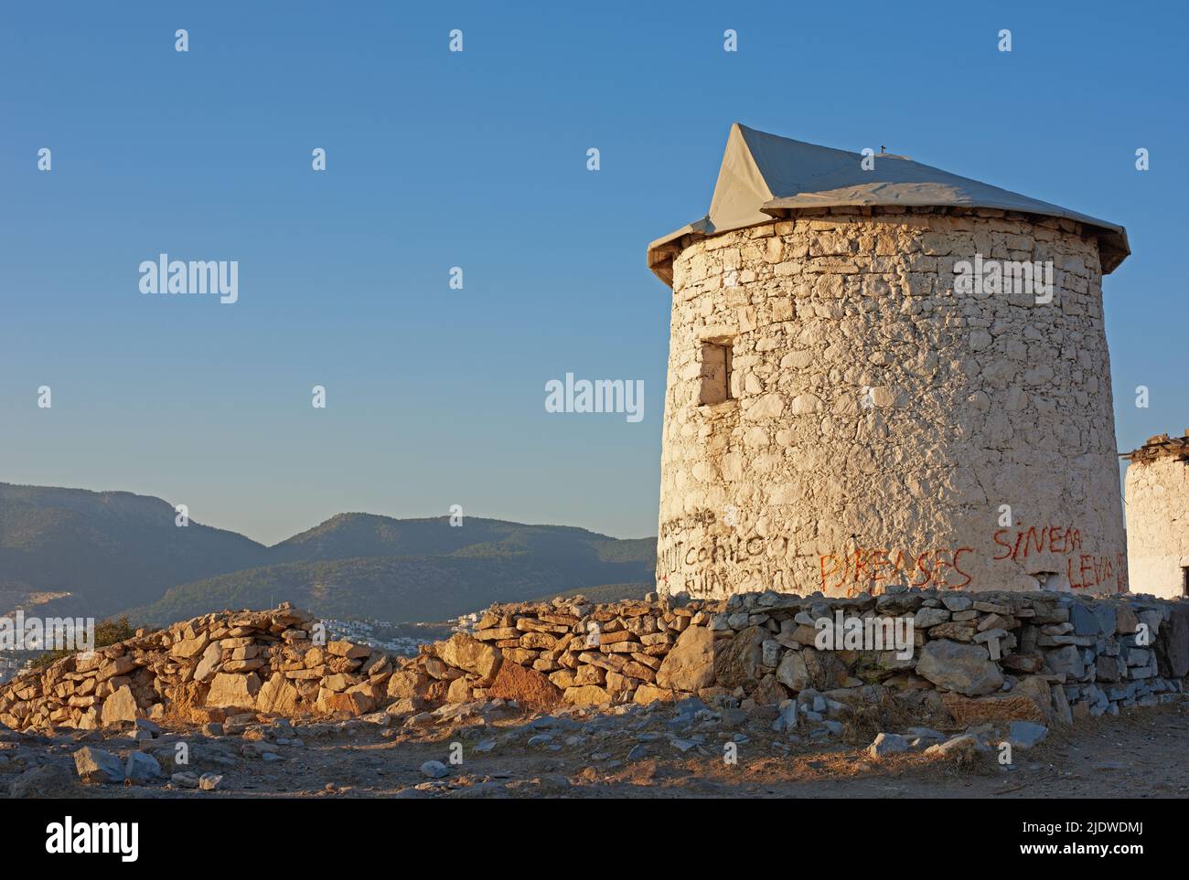 Old windmill in ruin near small village or countryside. A round ...
