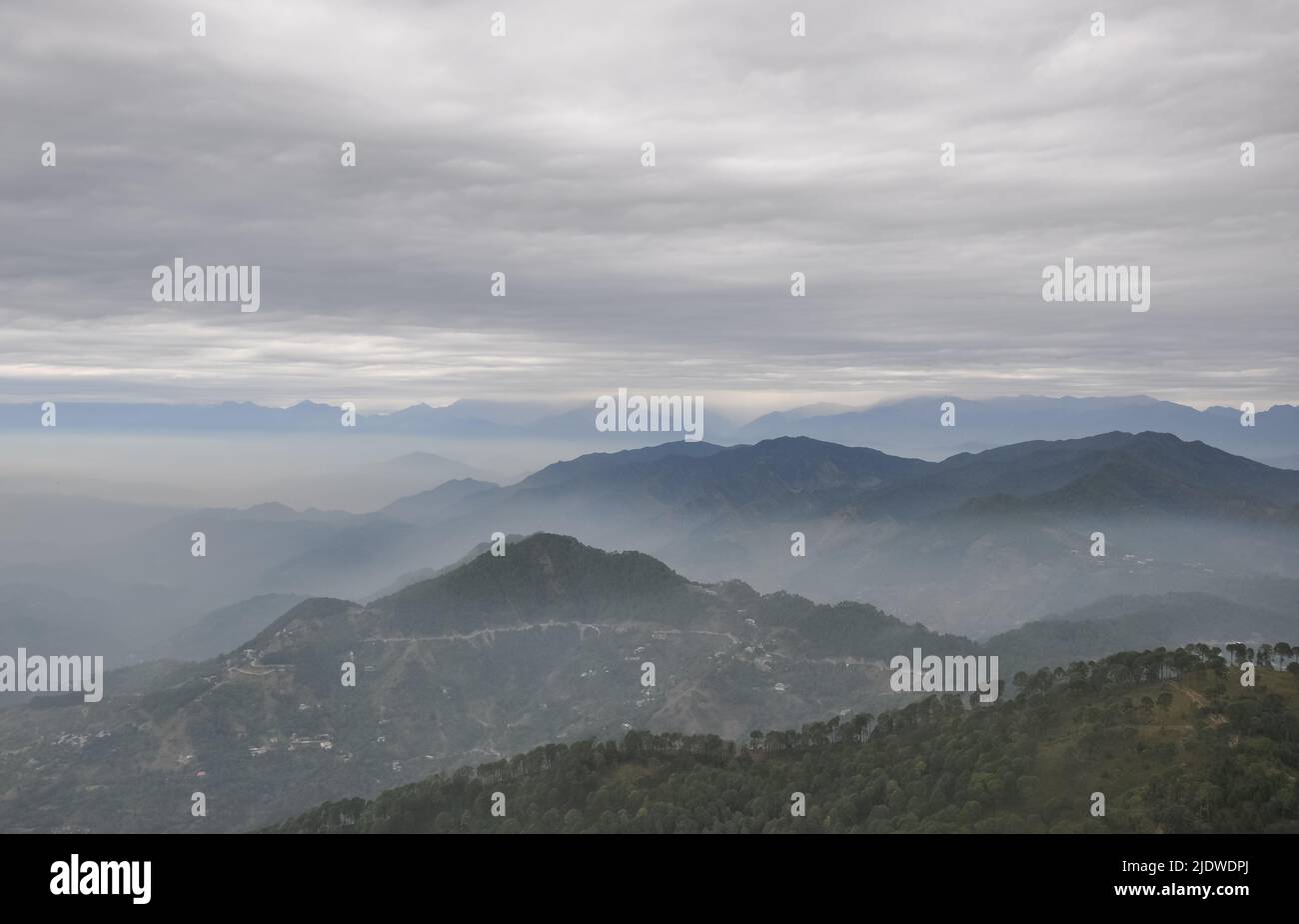Beautiful layers of mountains covered with fog in cloudy weather after ...