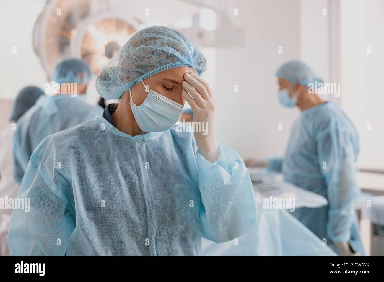 Close up of tired surgeon standing in operating room after hard surgery ...