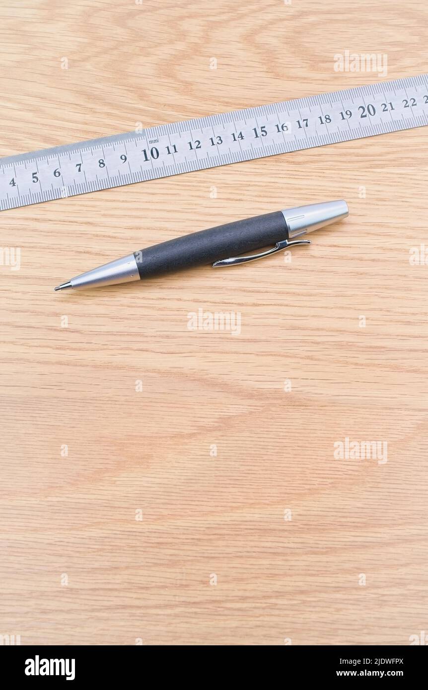 metal decimal ruler and pencil on a wooden desk Stock Photo - Alamy