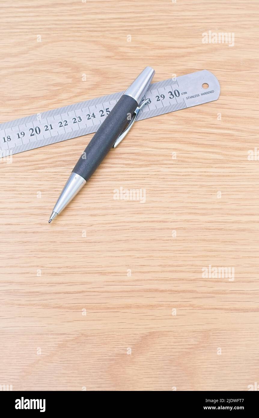 metal decimal ruler and pencil on a wooden desk Stock Photo - Alamy