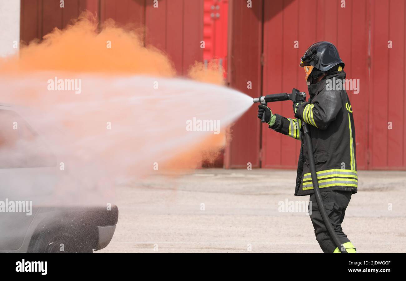 brave Fire Brigade extinguishes the fire with the hose by spraying ...