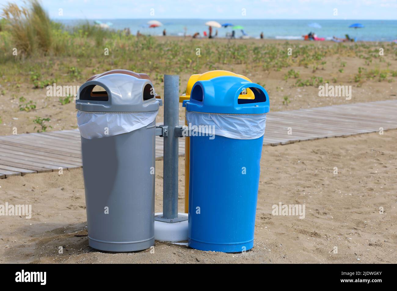 Four bins for the recycling of recyclable waste on the sandy beach ...