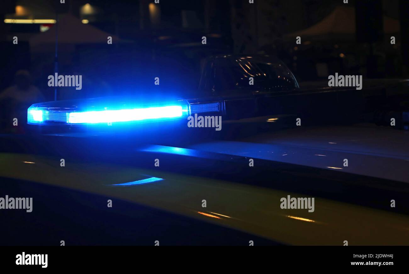 blue flashing of a police car siren during the night patrol around the ...