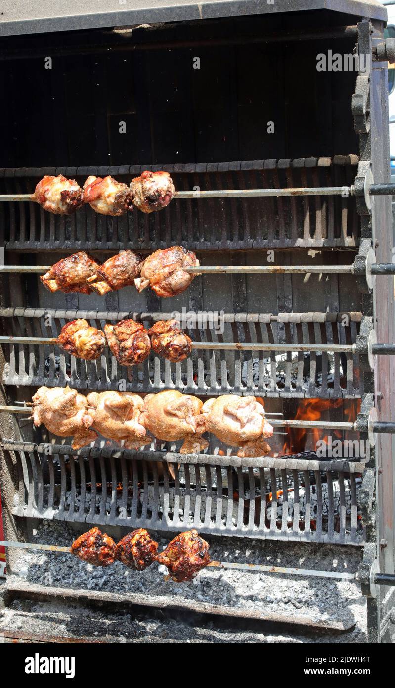 huge spit with roast chickens and pork knuckle while cooking in the ...
