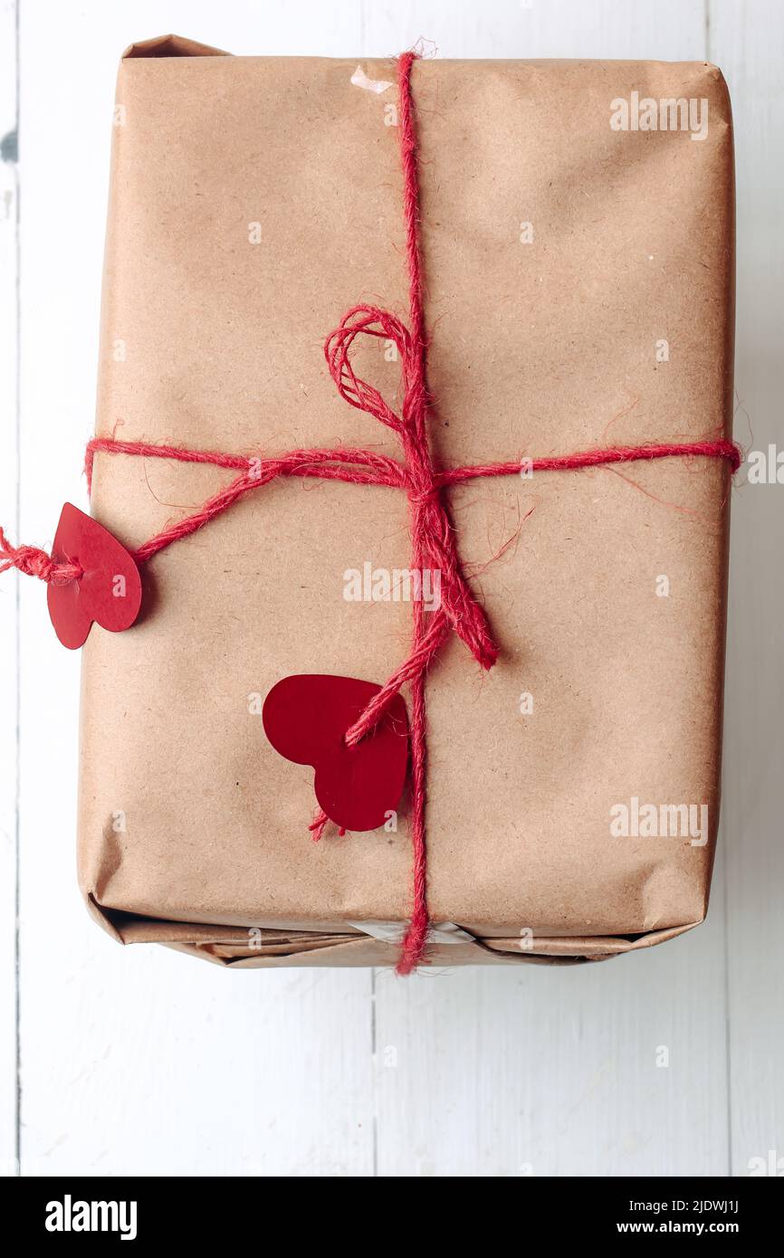 Gift box wrapped in kraft, tied with a rope with hearts. Eco-friendly ...