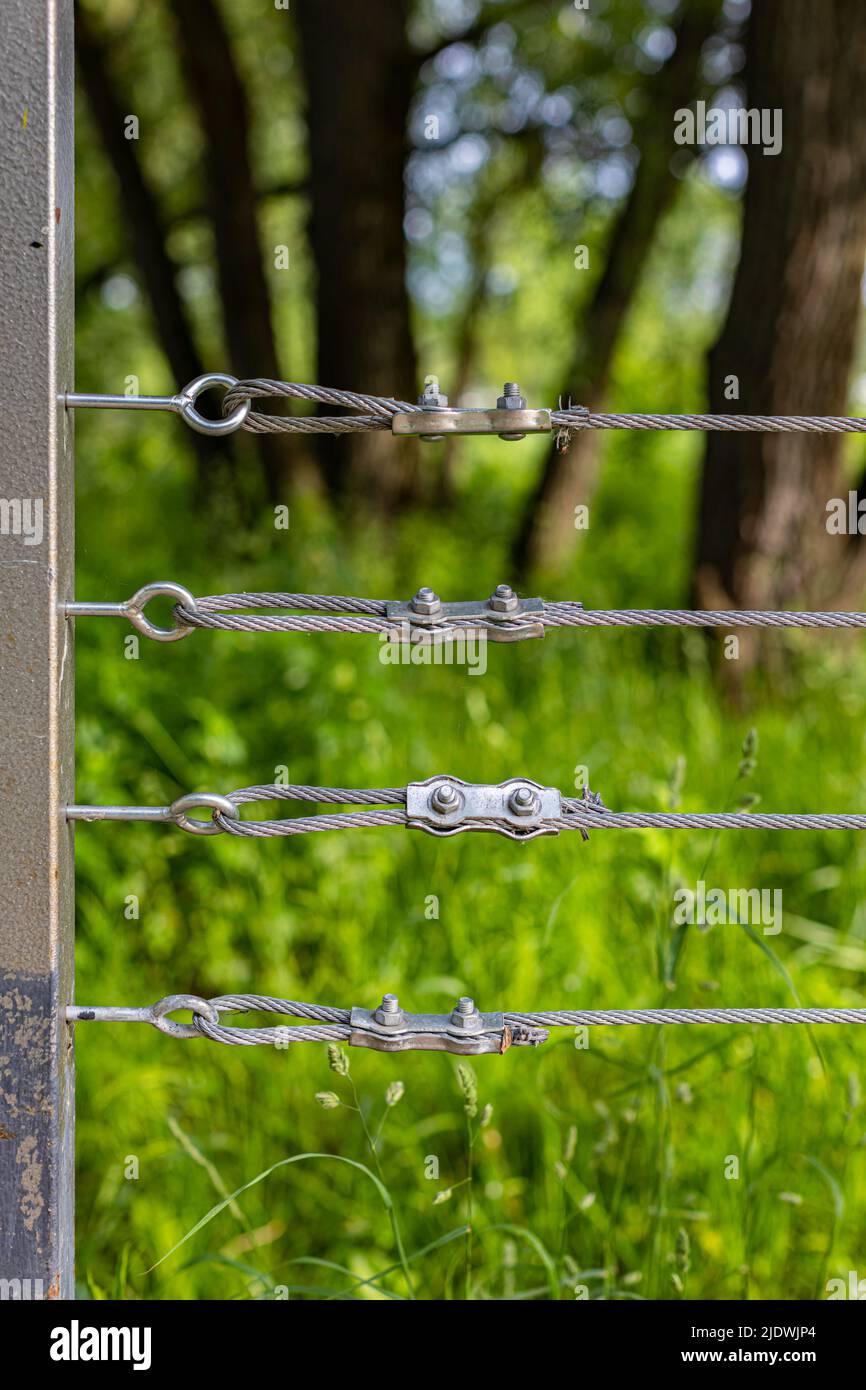 fixing a steel cable on a fence in a park. High quality photo Stock ...