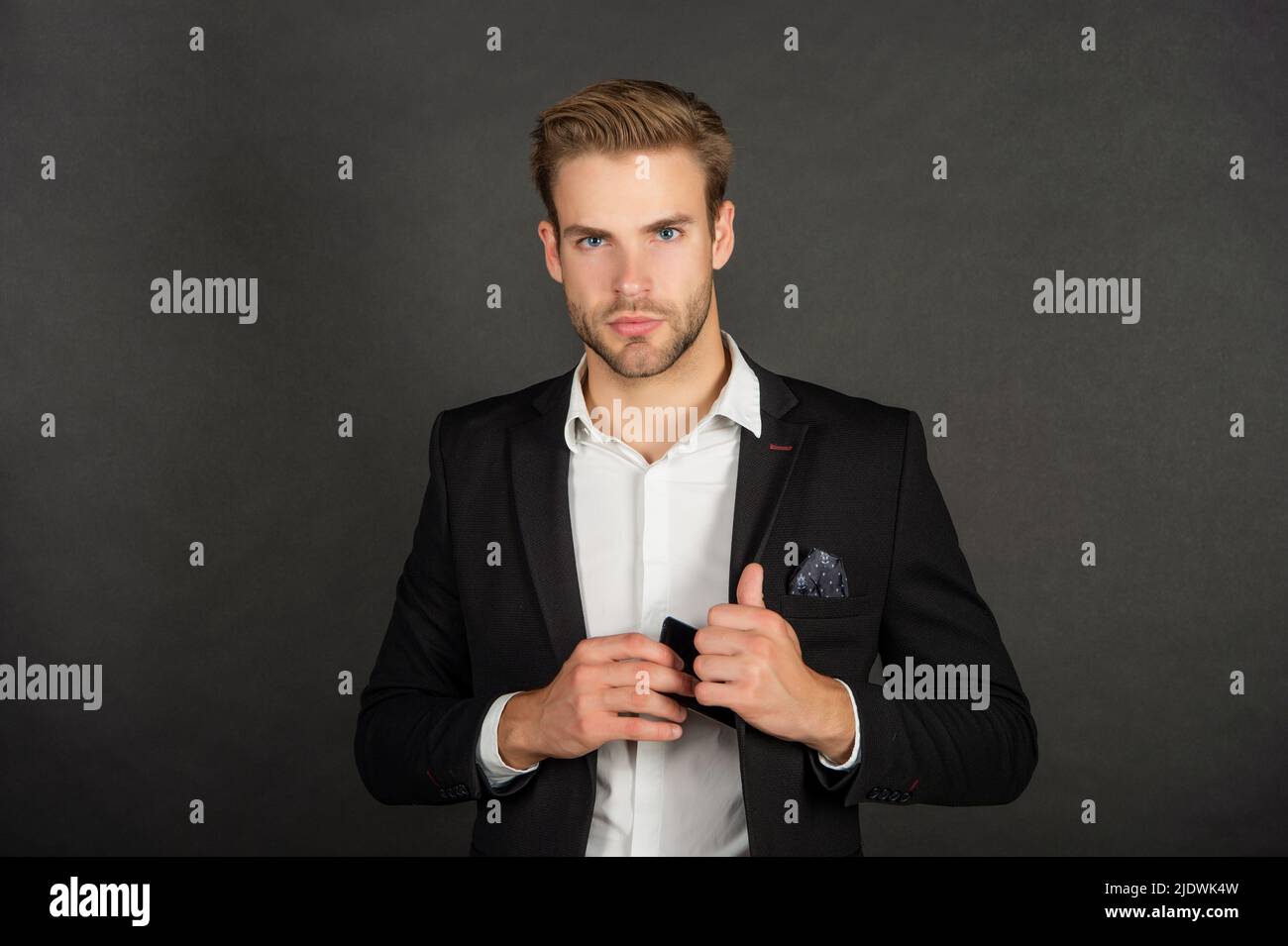 Act like a boss. Boss taking smartphone out of suit pocket ...