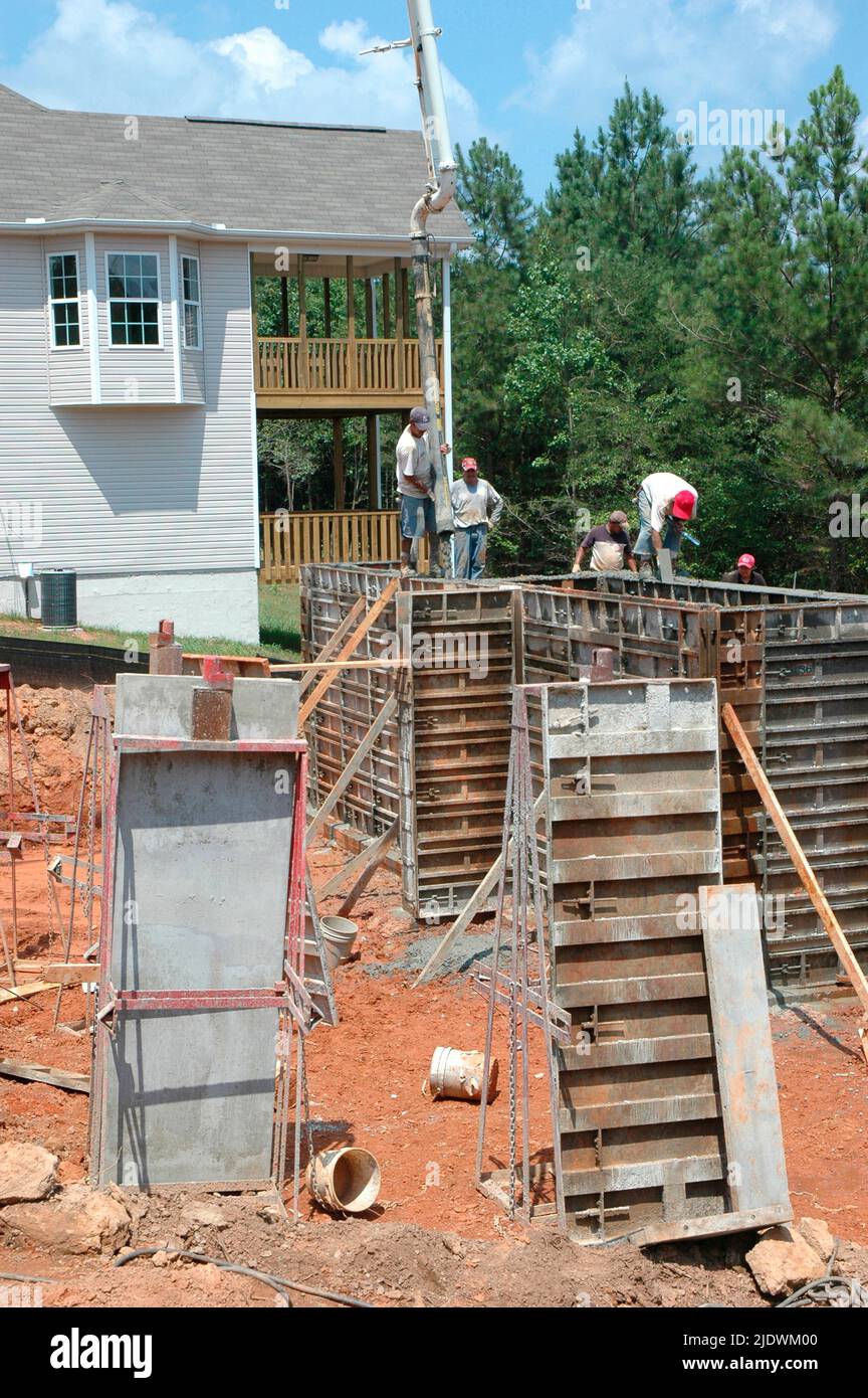 Foundation walls of cement being poured for new home construction by ...