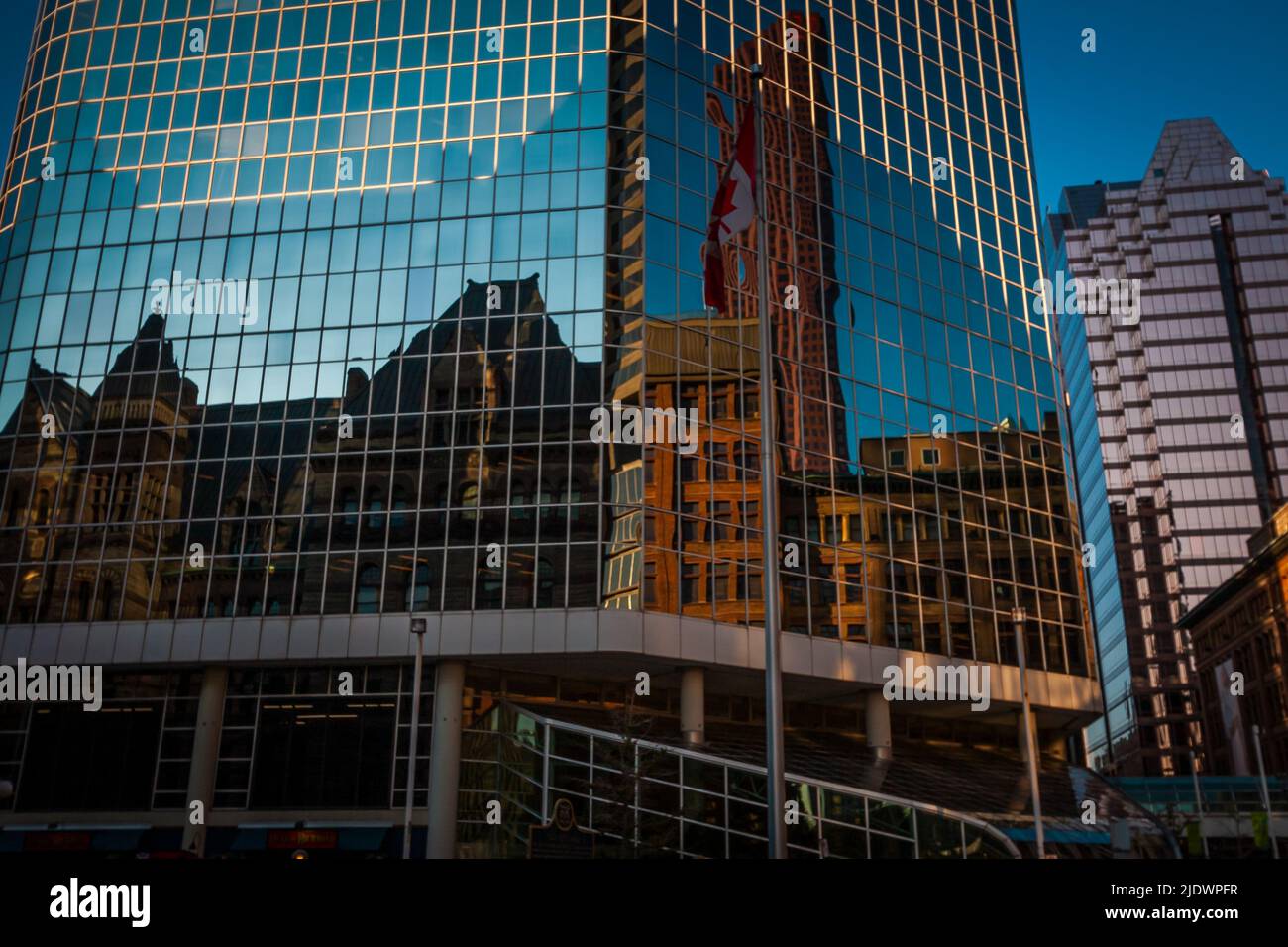 Building with glass windows reflecting other surrounding buildings in ...