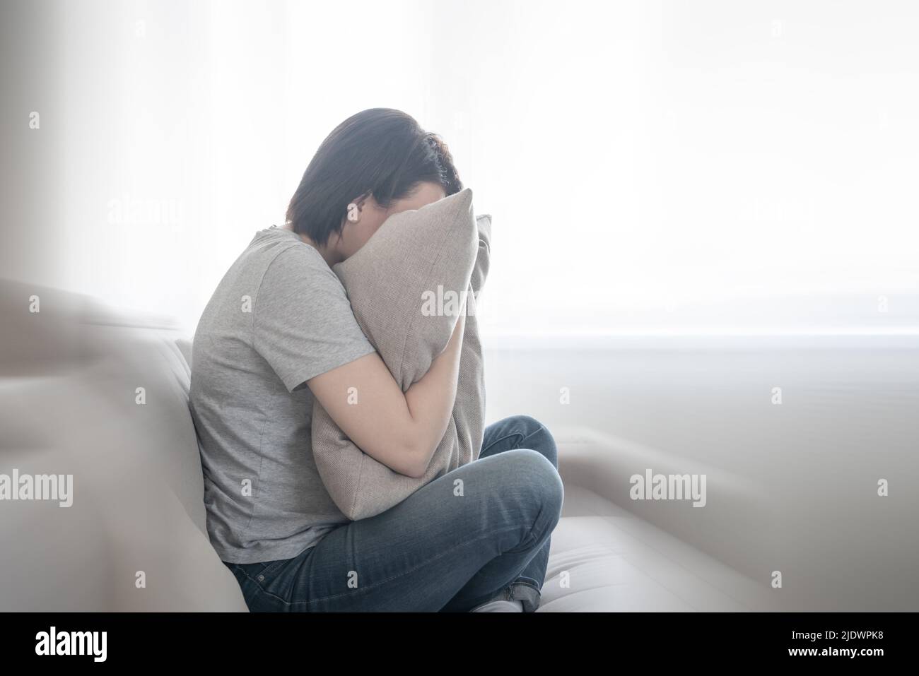 Sad depressed woman crying at pillow, loneliness and sadness concept ...