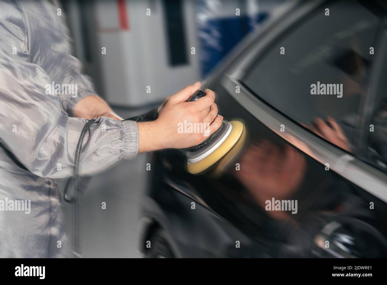 Worker polishing car with special grinder and wax from scratches at the ...