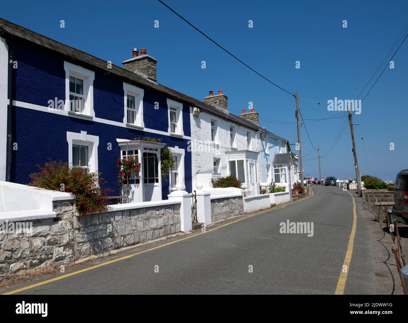 Row of old cottages houses homes along a street facing the sea with ...