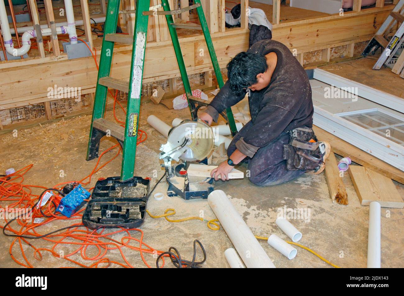 Plumbing installation crew putting in plastic and copper pipes into new ...