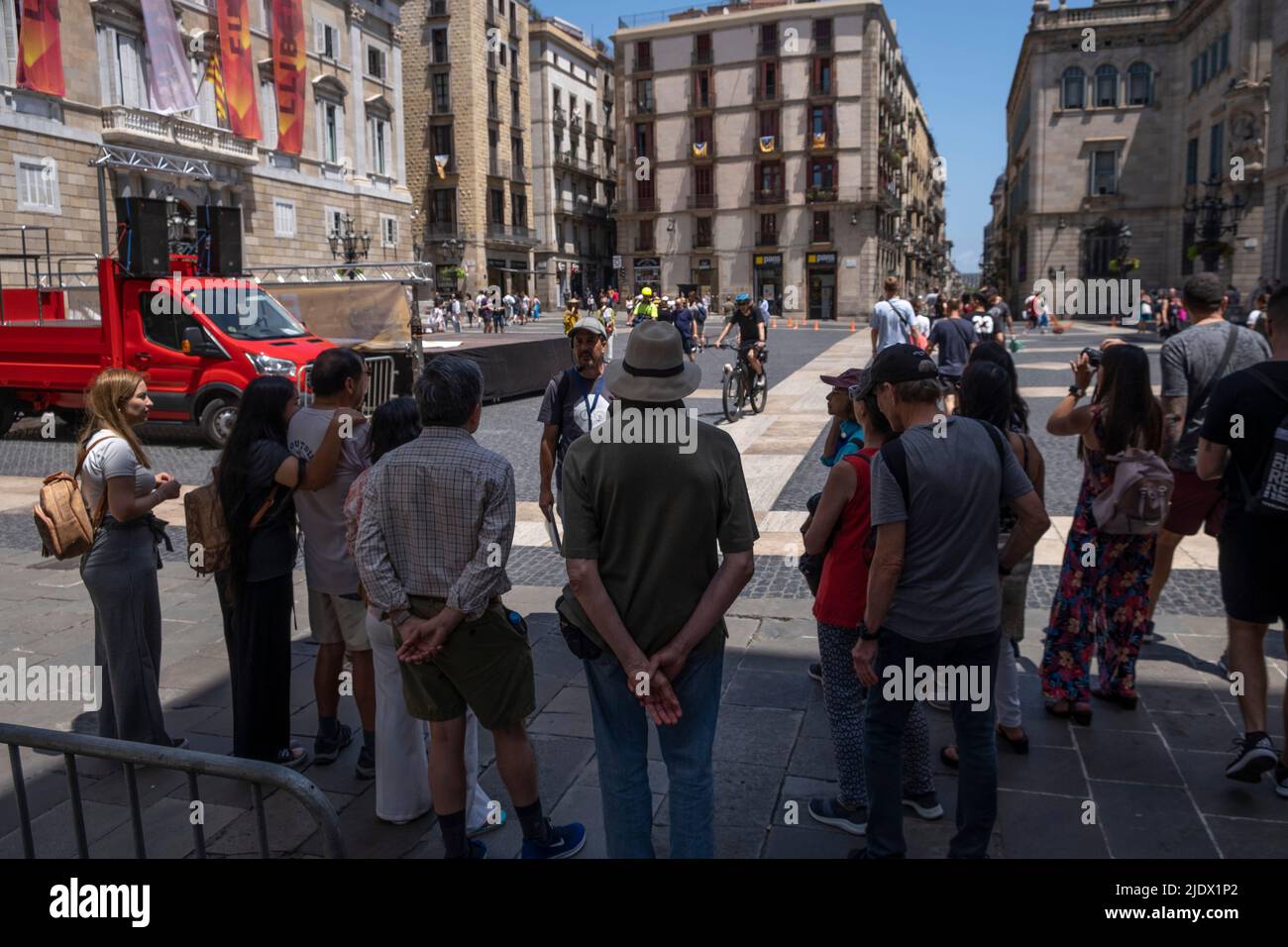 A tour group is seen receiving a briefing by a tour guide in Plaza de ...