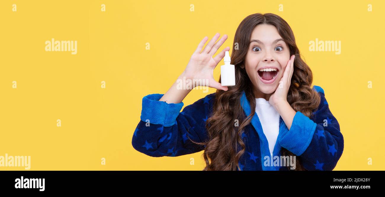 surprised kid girl in sleepwear using nasal spray against stuffy nose ...