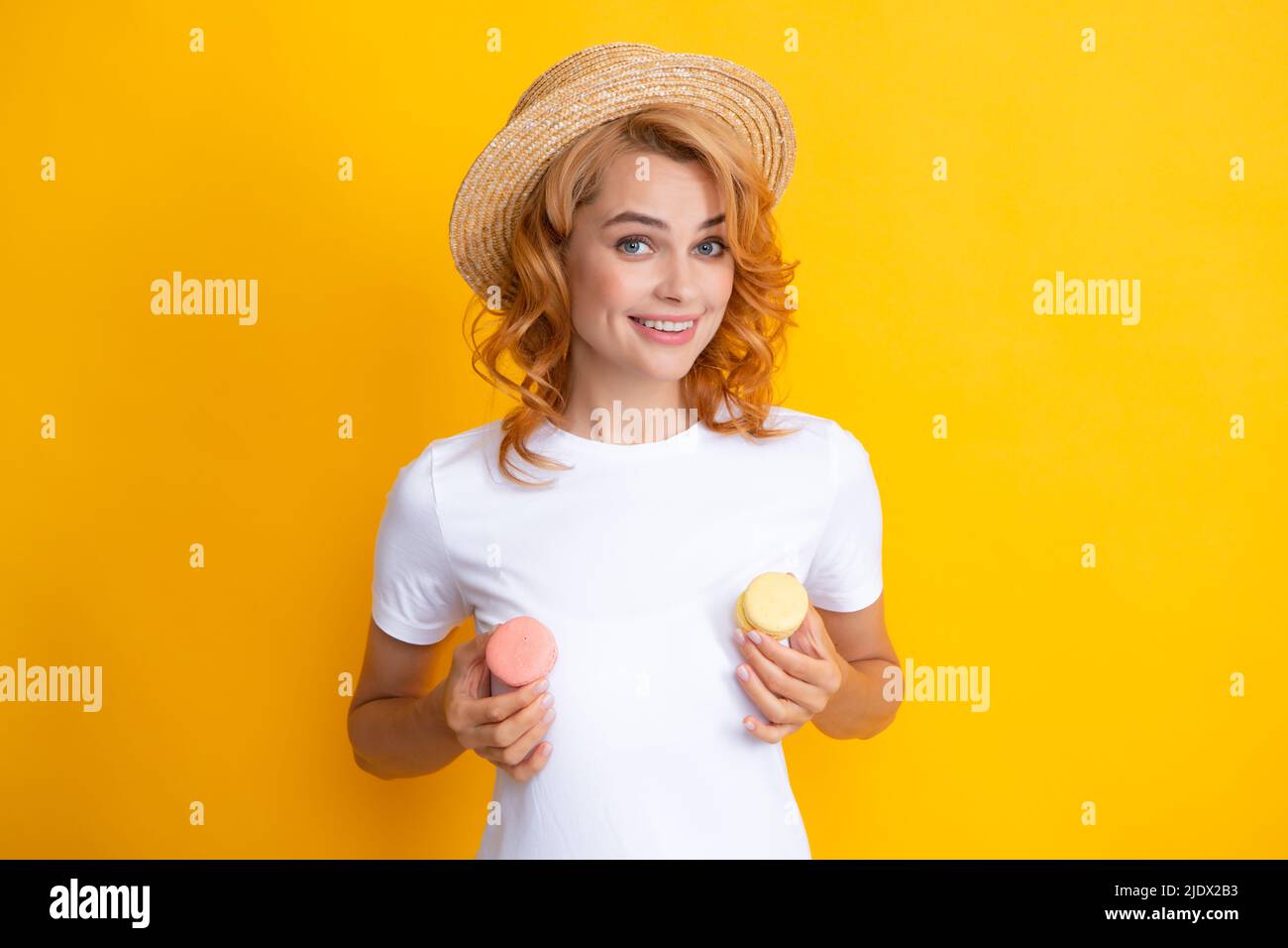 Cute young woman hold macaroon. Beautiful smiling young girl eating ...