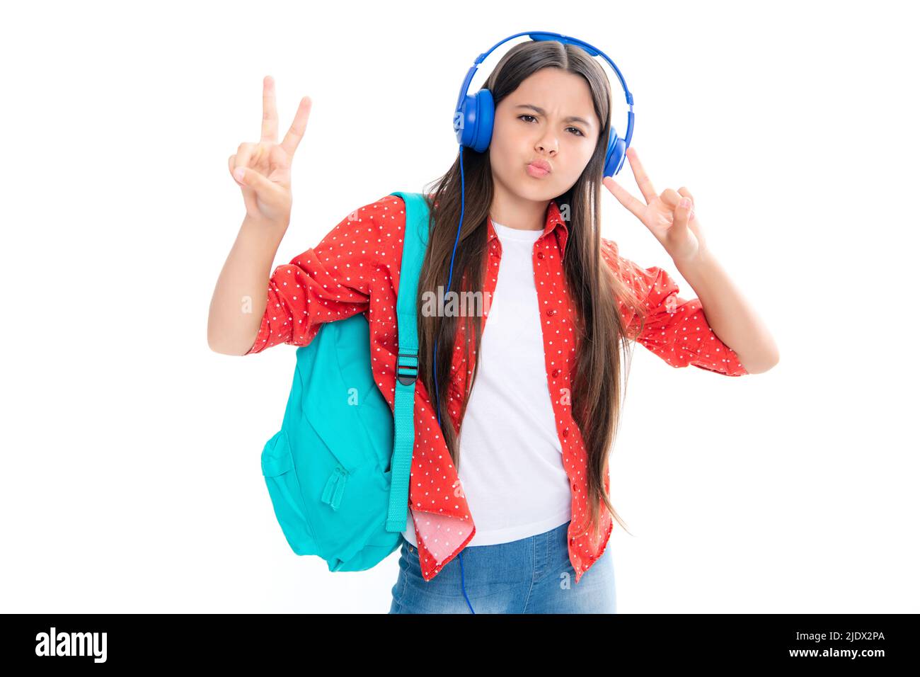 Funny face. School girl in headphones on isolated studio background ...