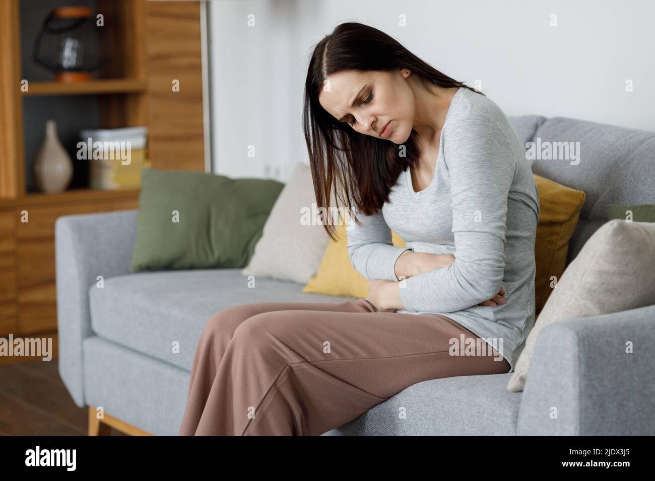 Sick young woman suffering from menstrual pain. Woman with hands ...