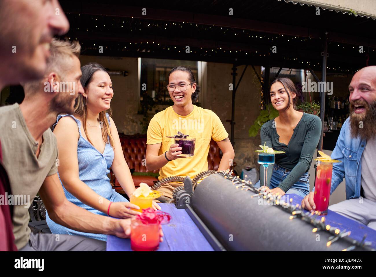 Gathering of merry friends happily spending time together and enjoying ...